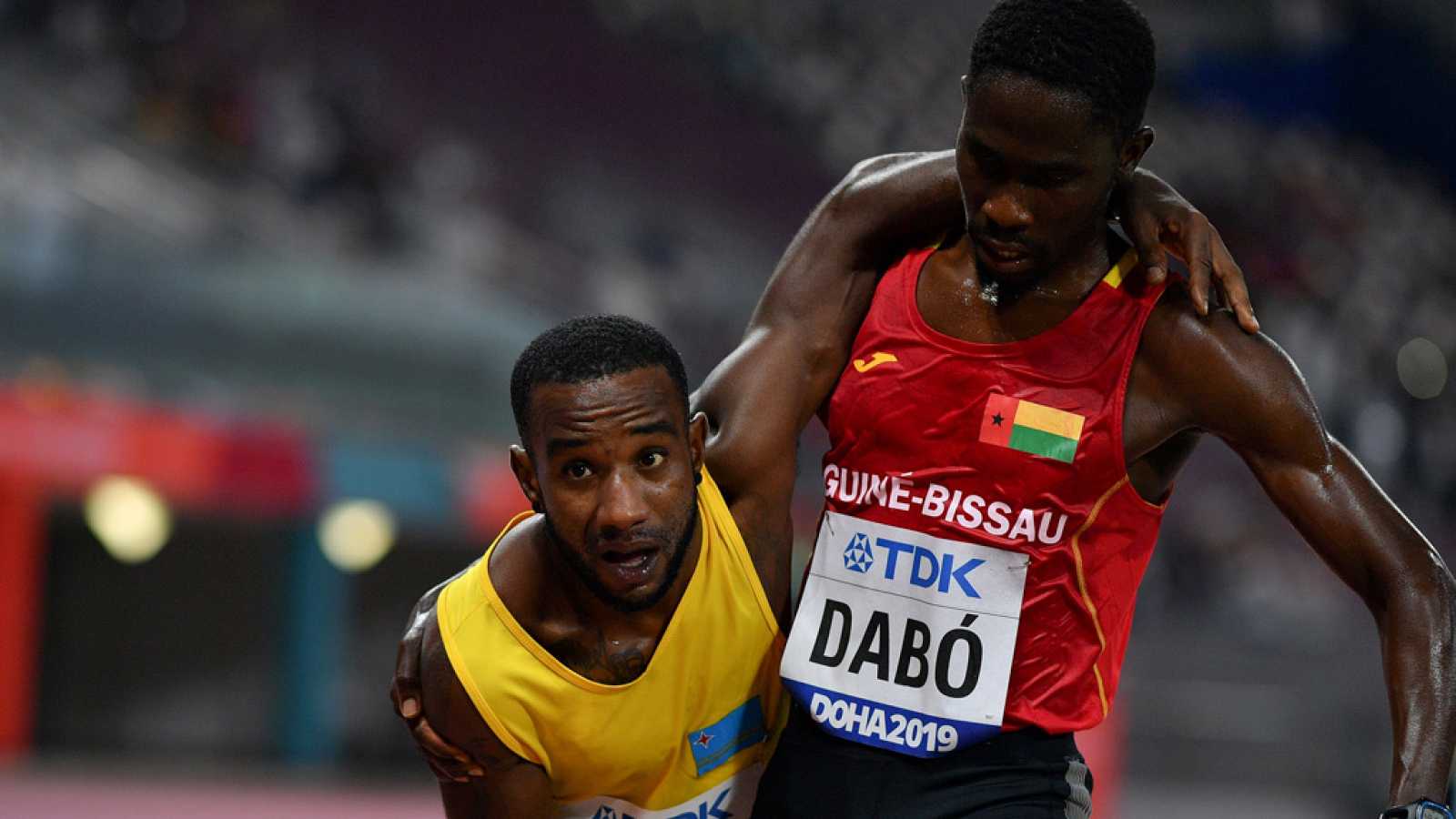 Jonathan Busby, de Aruba, completa los 5,000 metros ayudado por otro ...